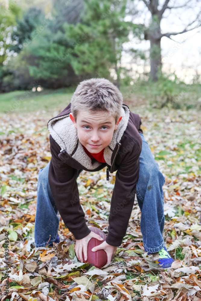Boy playing football in his backyard Stock Photo | Adobe Stock