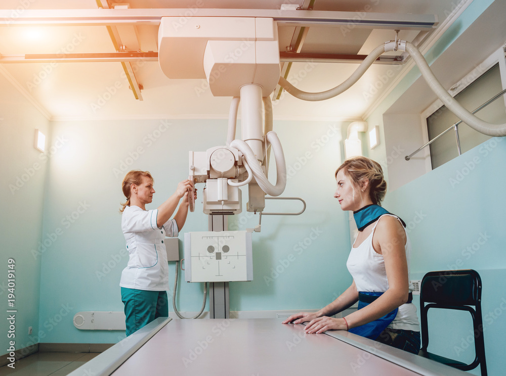 Radiologist and patient in a x-ray room. Classic ceiling-mounted x-ray ...