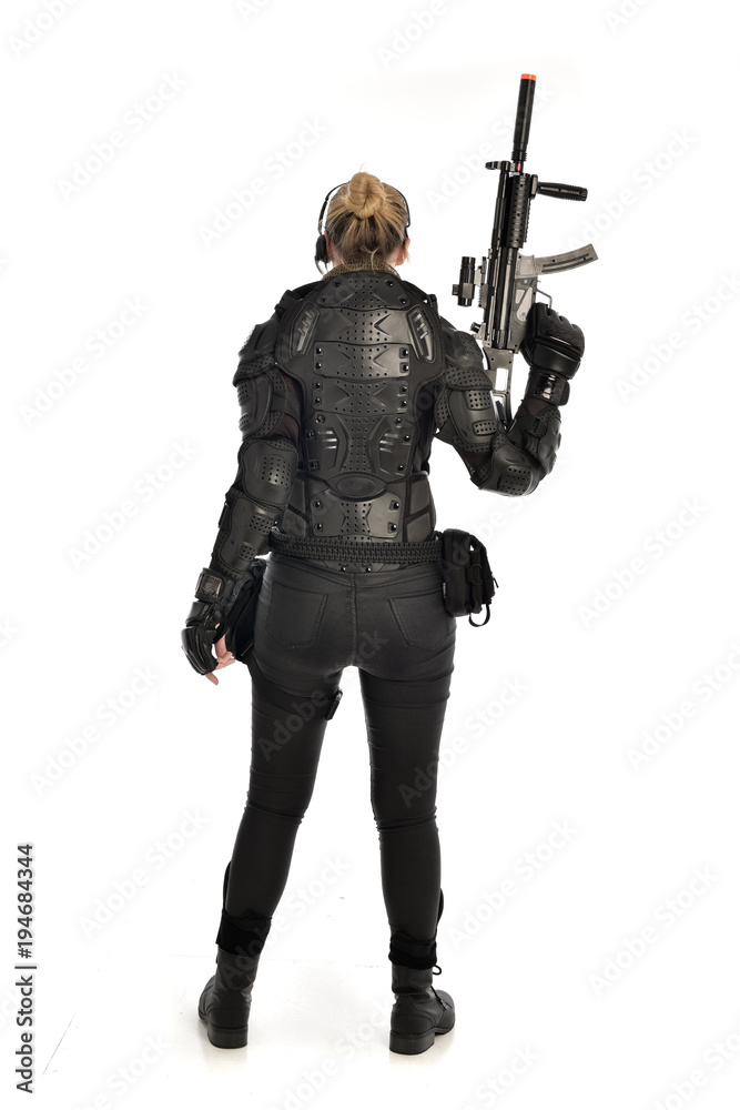 full length portrait of female soldier wearing black tactical armour ...