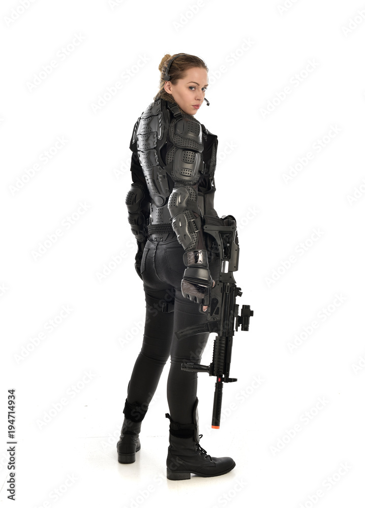 full length portrait of female soldier wearing black tactical armour ...