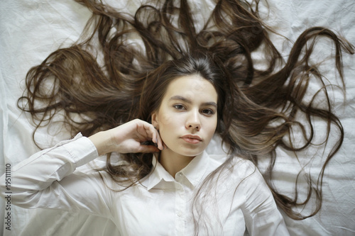 Brunette Beautiful Young Adult With Long Hair Lying On The Bed Buy