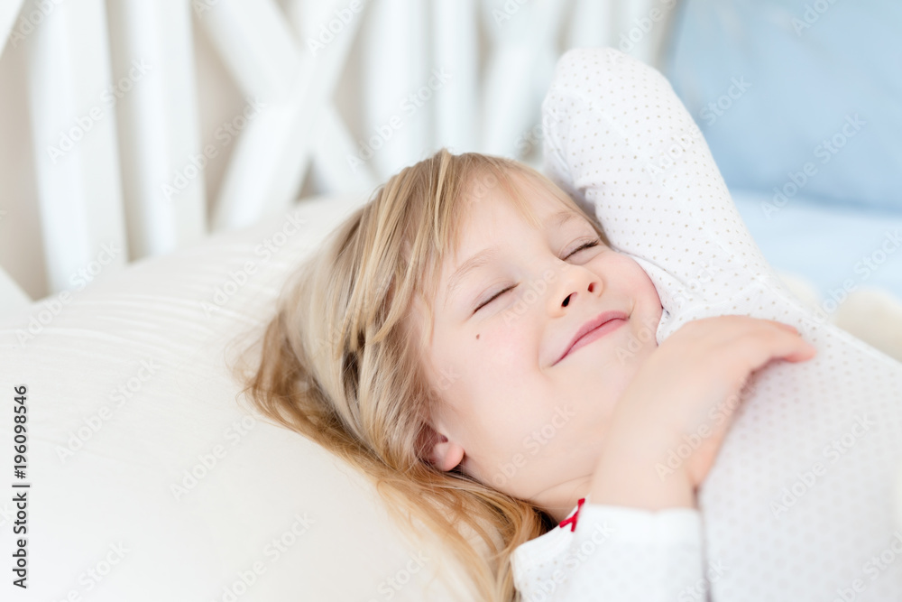 Little cute girl wake up in bed. Child stretching arms. Smiling and ...
