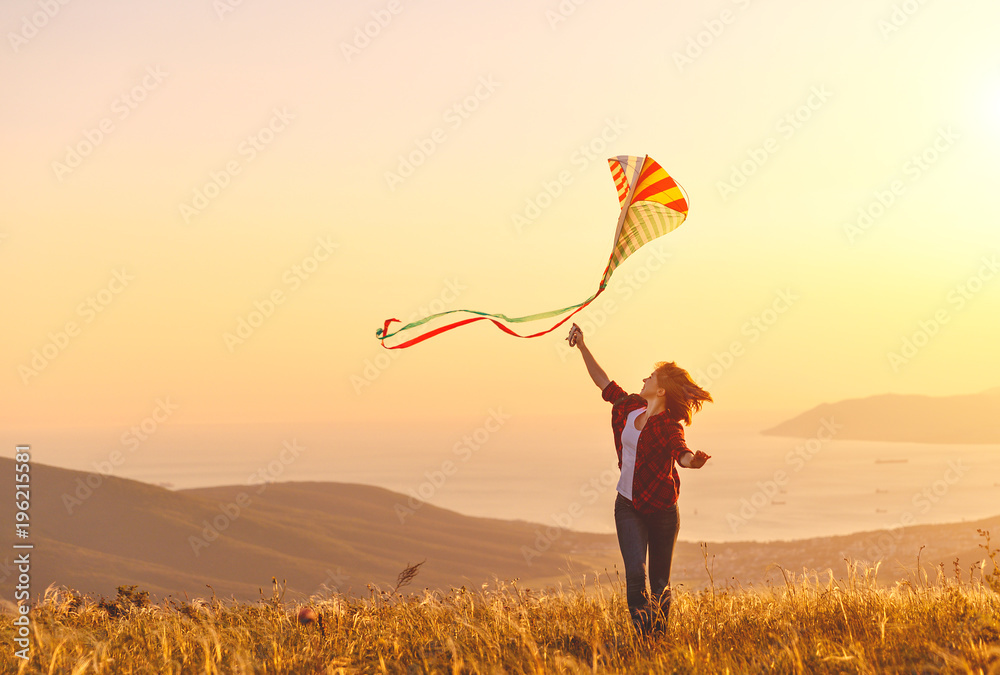Happy young woman running with kite on glade at sunset in summer. Stock ...