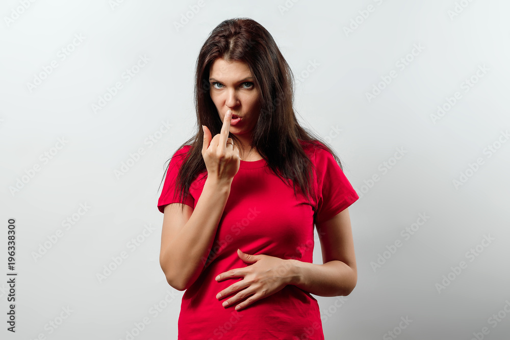 Young, beautiful girl showing the middle finger. Isolated on a light ...