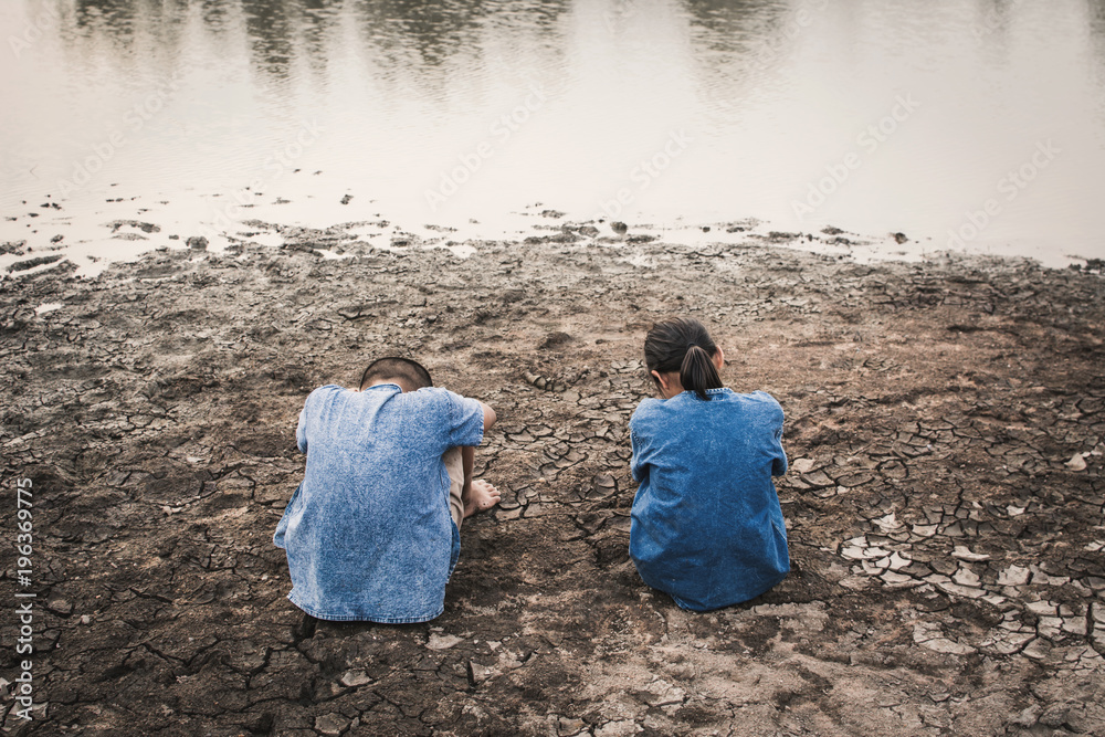 Foto de Stock Sad boy and girl sitting on cracked dry ground, Concept ...