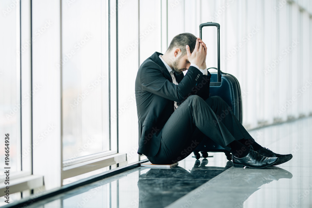 Serious businessman worrying something, sitting and touch his head at ...