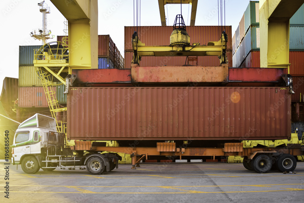 Heavy duty truck pick up shipping container at port. Gantry crane ...