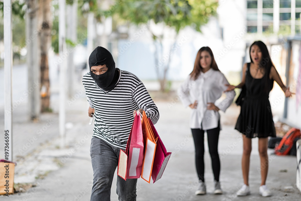 Thief run away after stealing shopping bag from women on street.With ...