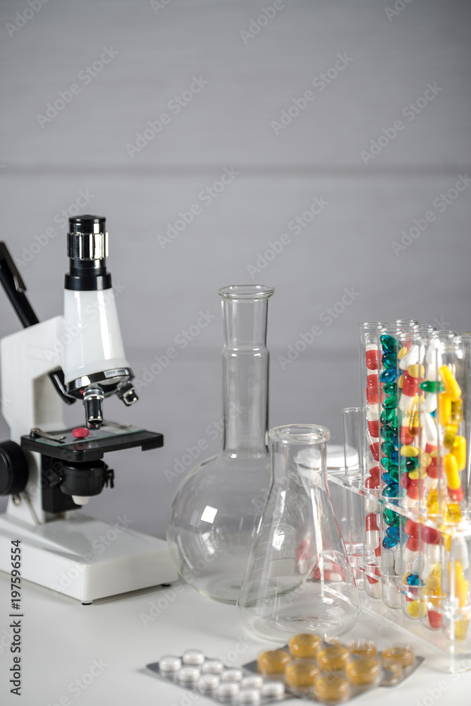 Laboratory Microscope, pills and test tubes. Scientific and healthcare ...
