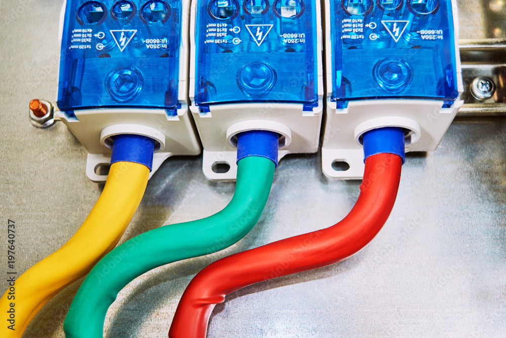 Three electrical cables or wires are connected to the distribution ...