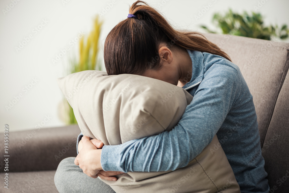 Sad woman hugging a pillow Stock Photo | Adobe Stock