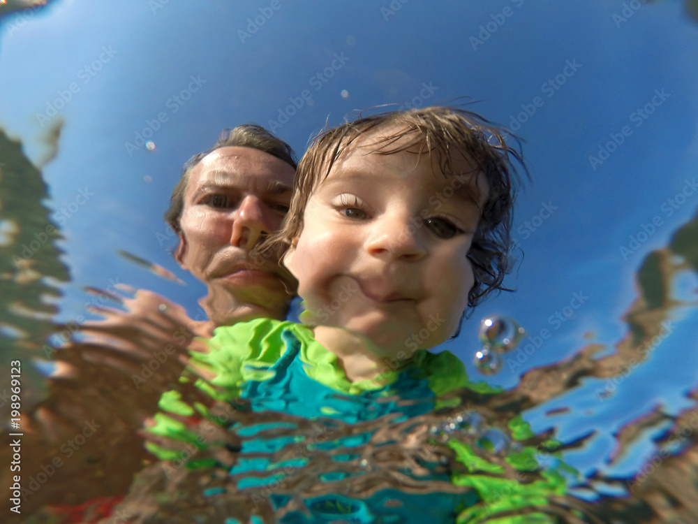 Underwater view of a father and her daughter with distorted faces ...