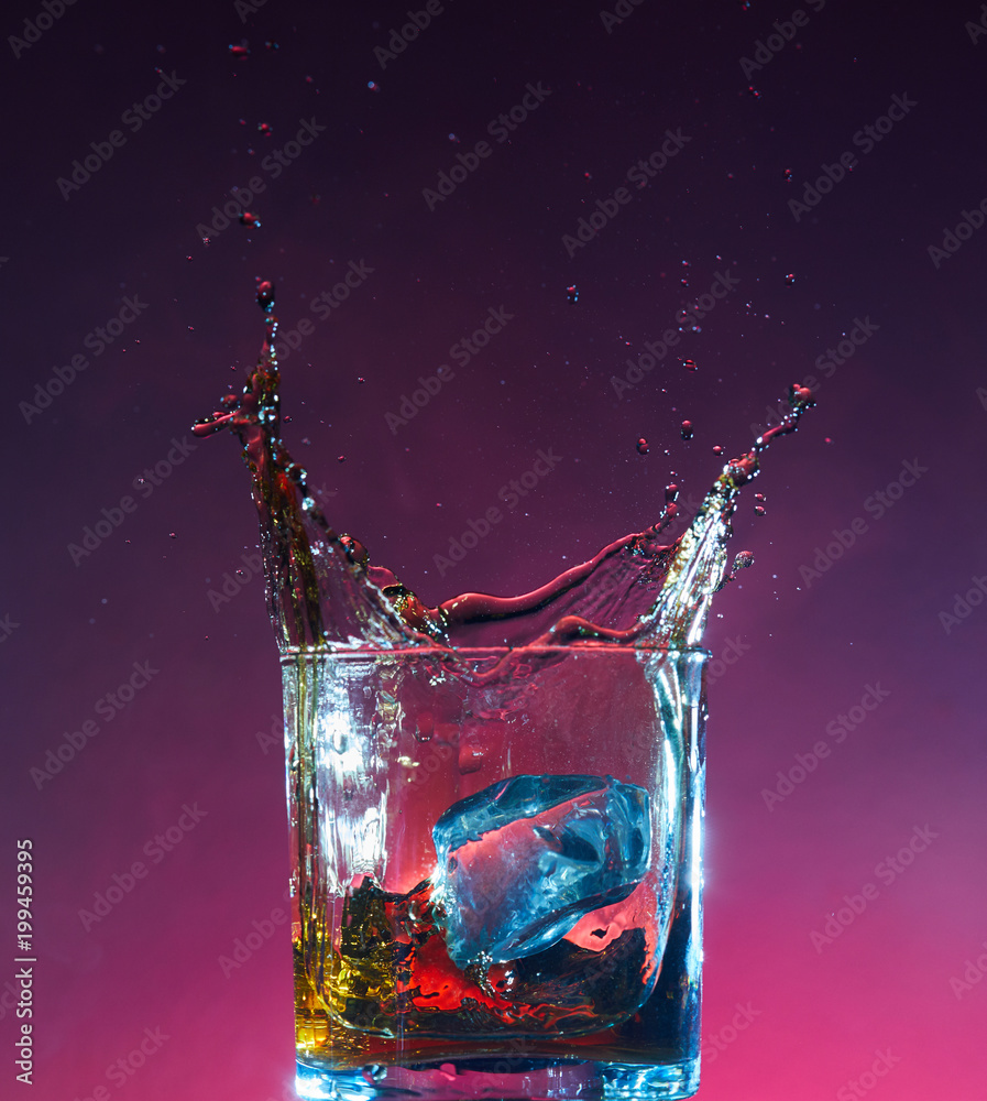 water liquor whisky splash in clear glass with colorful background ...