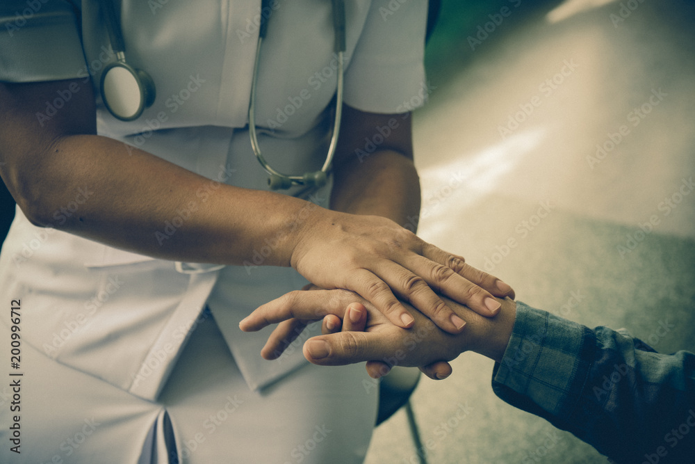 Nurse holding the hand of a patient man, showing sympathy and kindness ...