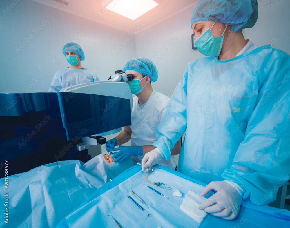 Laser vision correction. A patient and team of surgeons in the ...