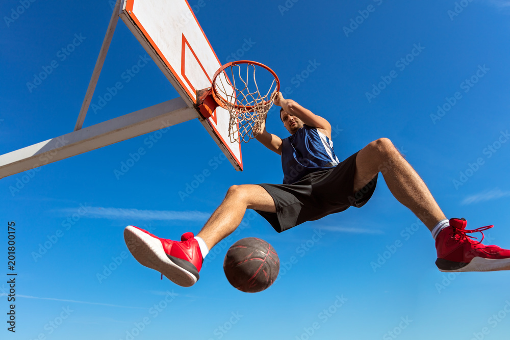 Slam Dunk. Side view of young basketball player making slam dunk Stock ...