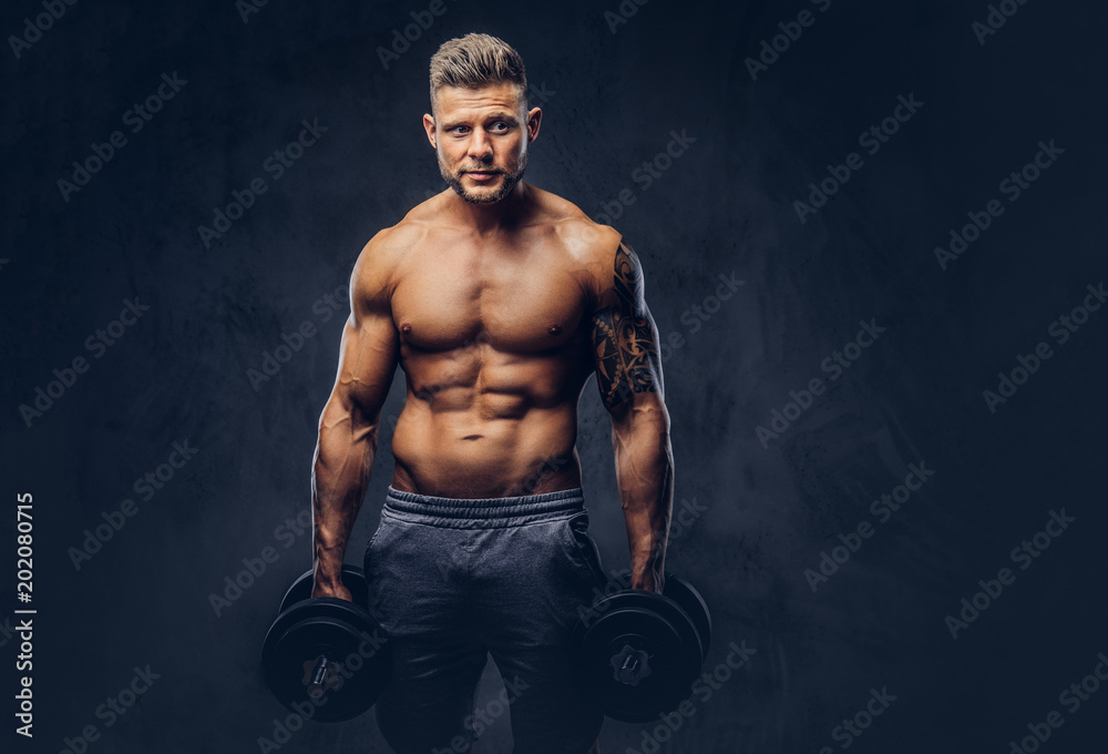 A handsome shirtless tattooed bodybuilder with stylish haircut and ...