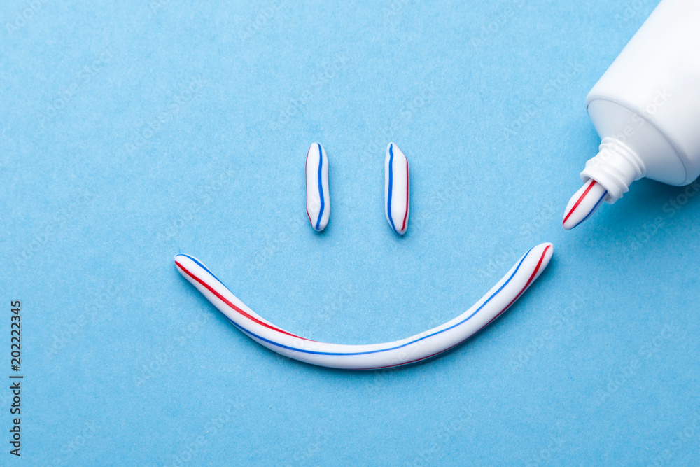 Tooth-paste in the form of a face with a smile. Tube of toothpaste and ...