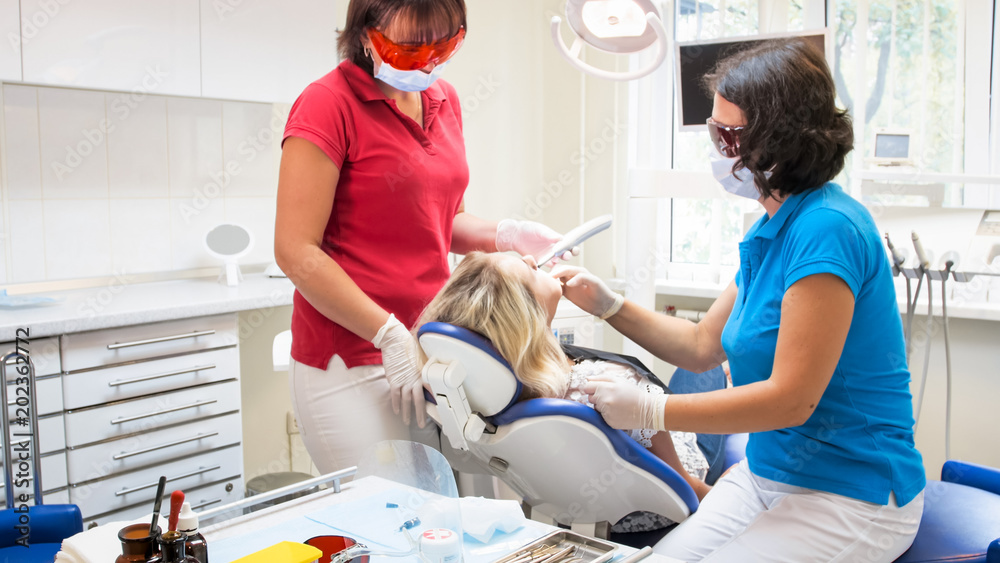 Dentist treating patients teeth with dental curing UV lamp Stock Photo ...