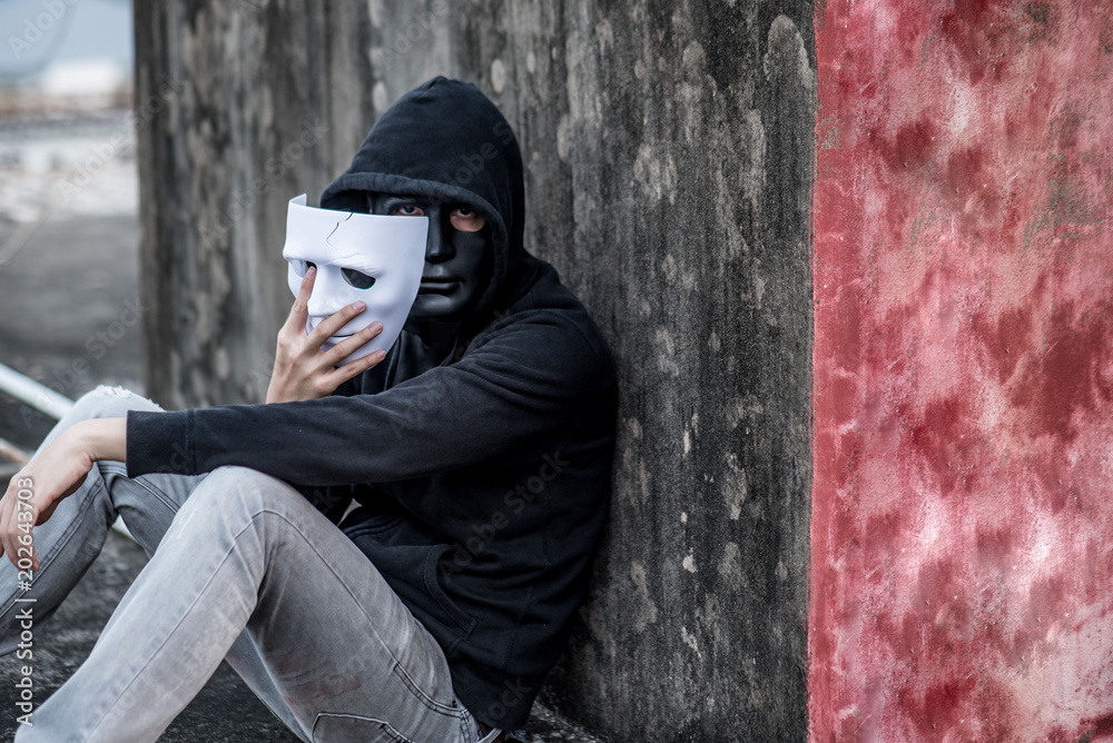 Mystery man wearing hoody jacket taking off the mask showing another ...