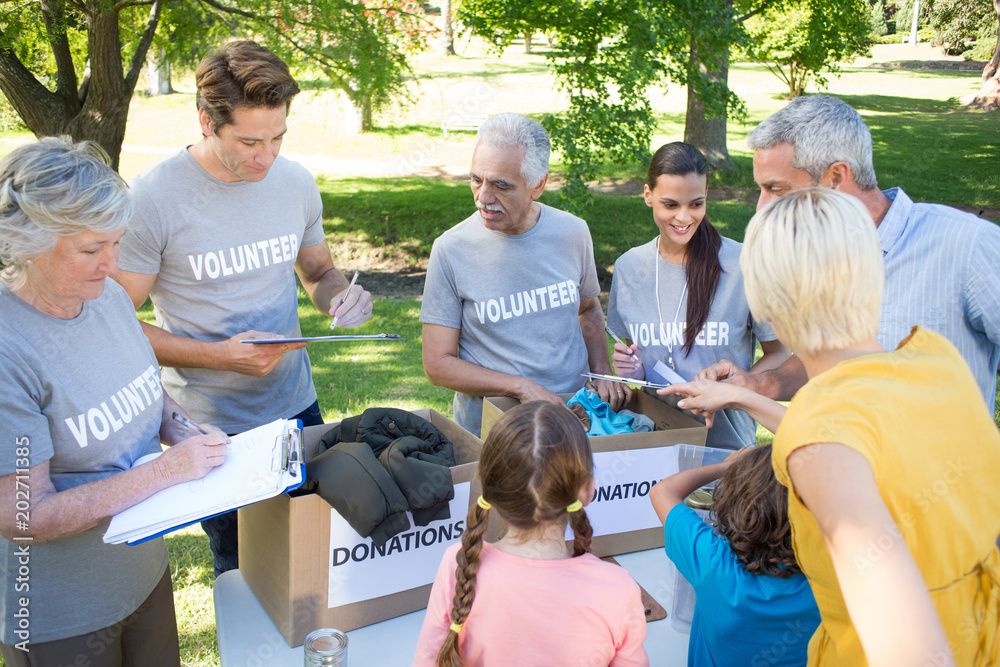 Happy volunteer family separating donations stuffs Stock Photo | Adobe ...