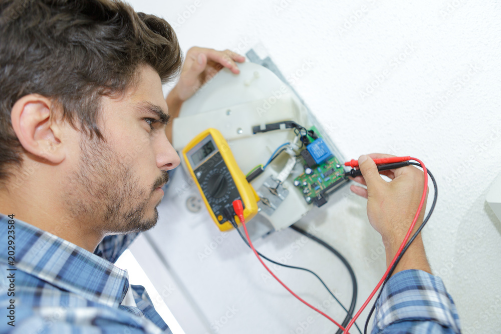 tradesman fixing electrical issue with hand dryer Stock Photo | Adobe Stock