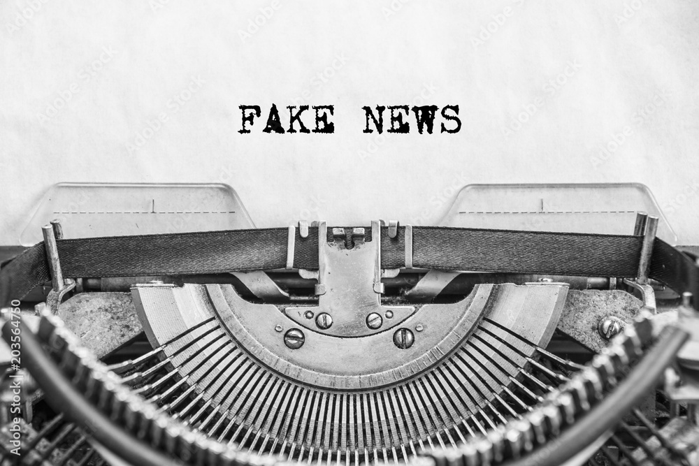 the text FAKE NEWS is typed on old paper by a vintage typewriter close ...