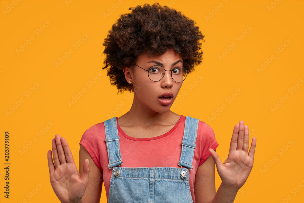 Discontent African American female makes stop sign with palms ...