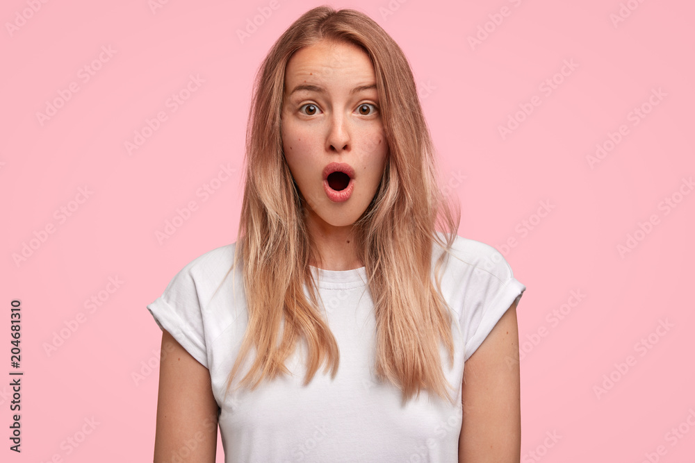 Photo Stock Isolated shot of surprised European female in white t shirt ...