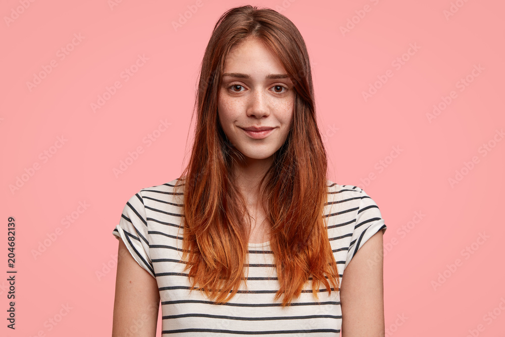 Headshot of good looking freckled female has long hair, pleasant ...