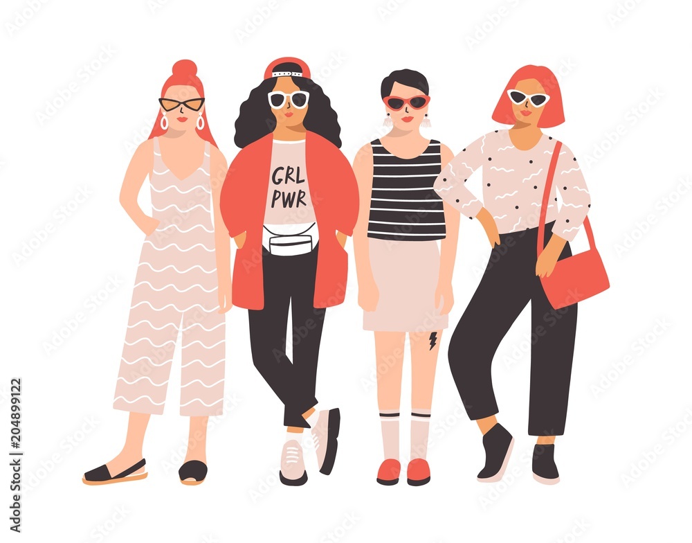 Four young women or girls dressed in trendy clothes standing together ...