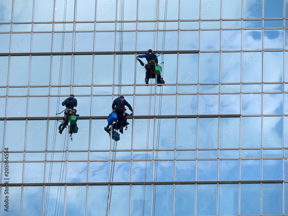 Climbers wash windows and glass facade of the skyscraper. Window ...