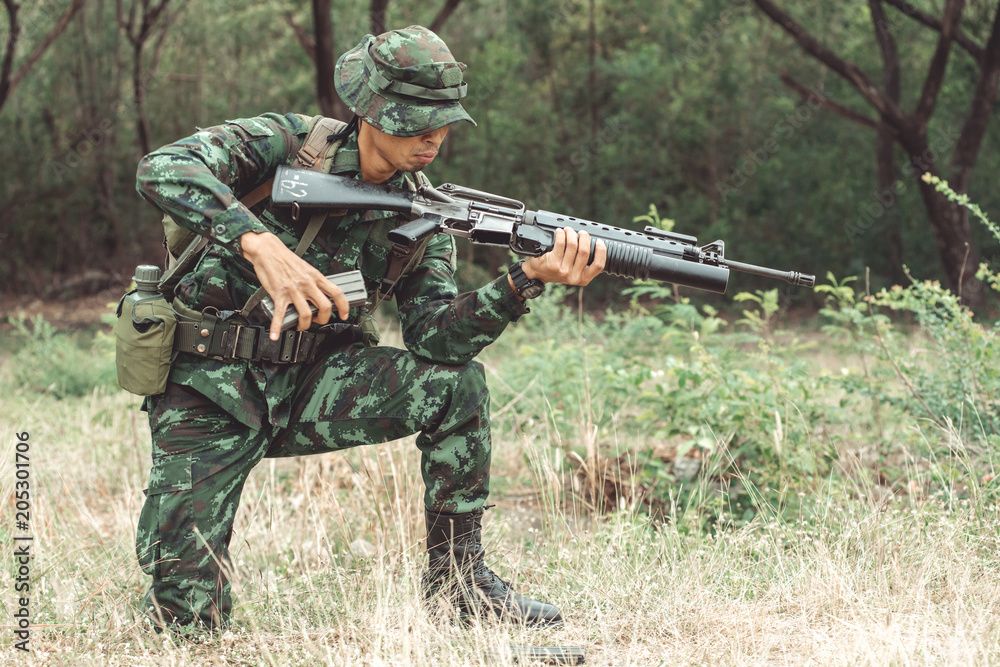 Soldier reloading his assault rifle. Chinese professional soldier ...