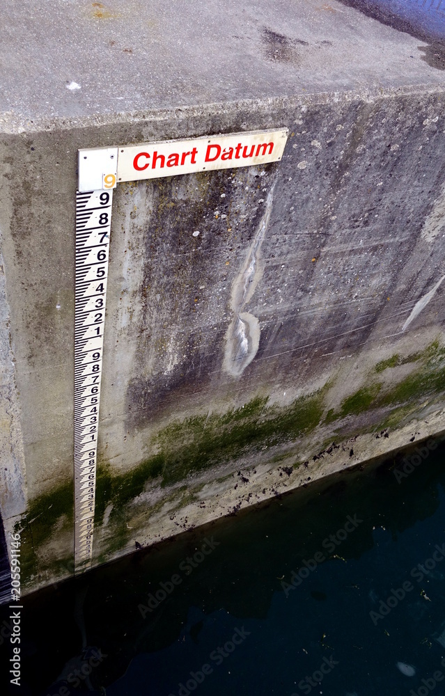 Tide gauge or tide staff on a harbour wall, showing chart datum, used ...