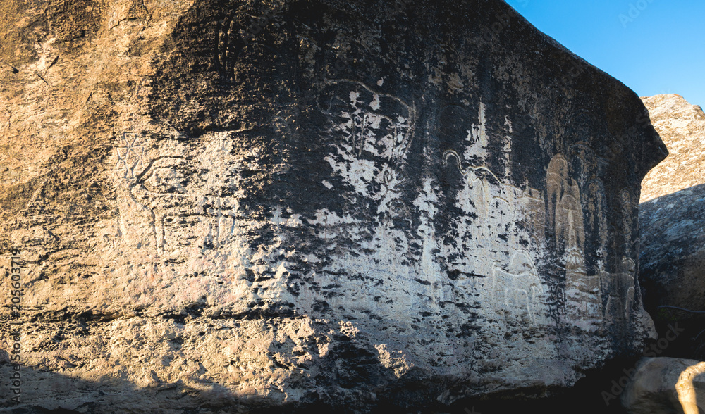 Ancient prehistoric drawings of various animals on the rock. The ...