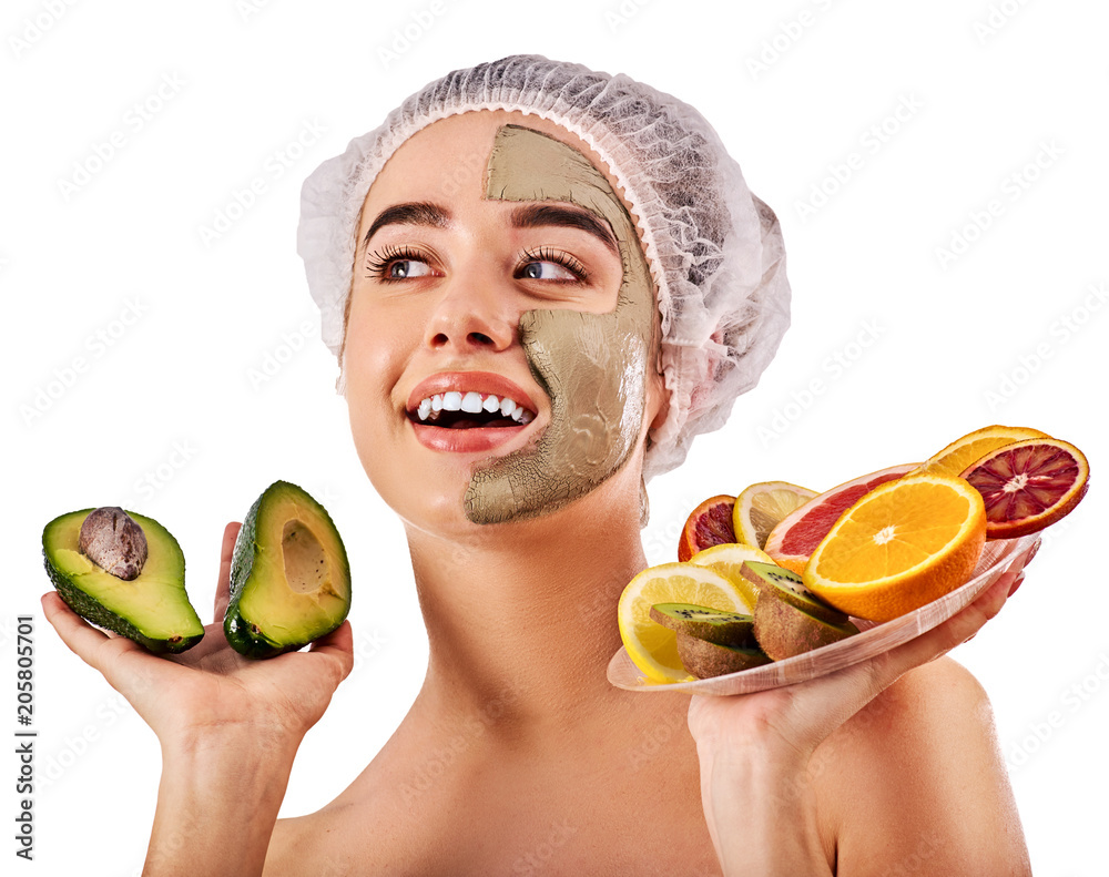 Avocado clay face mask. Woman in medical hat holding half of green ...