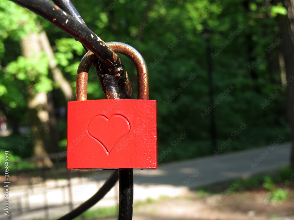 Red padlock with love heart image. Closed rusty lock in the summer park ...