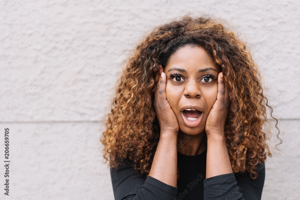 Shocked young African woman gawping at camera Stock Photo | Adobe Stock