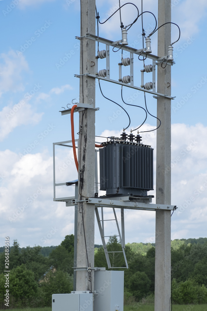 Electric transformer stands on concrete supports. Stock Photo | Adobe Stock