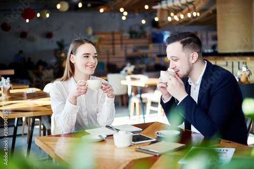 Two coworkers, businessman and businesswoman having coffee together ...