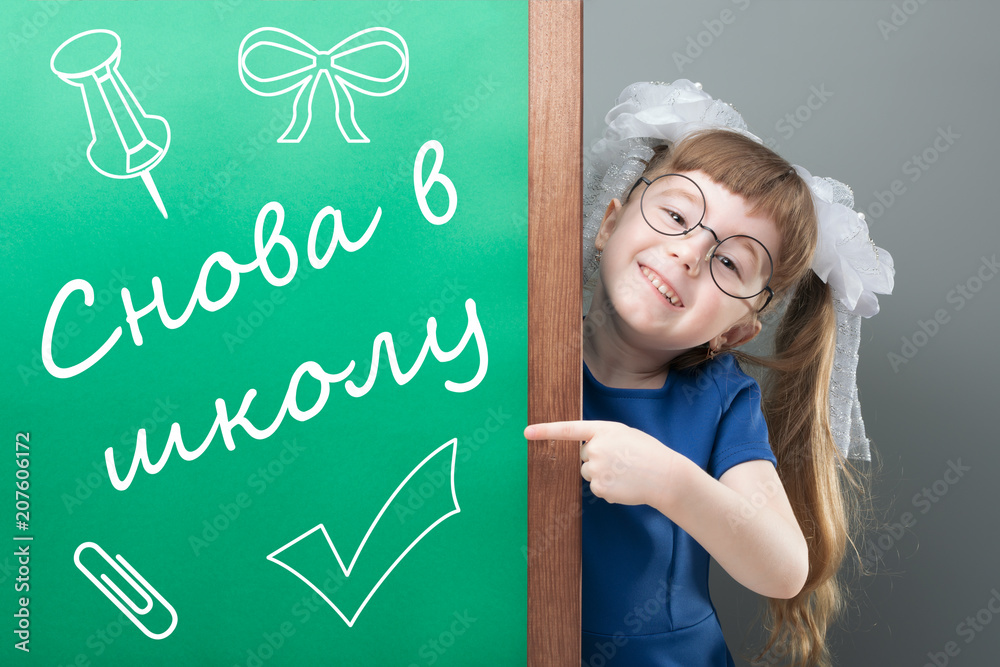 Smiling female kid with tails and glasses presenting green wall with ...