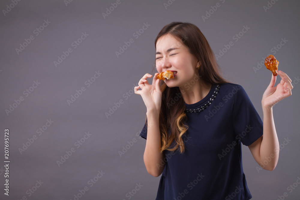 woman eating unhealthy fat fried chicken; portrait of unhealthy girl ...