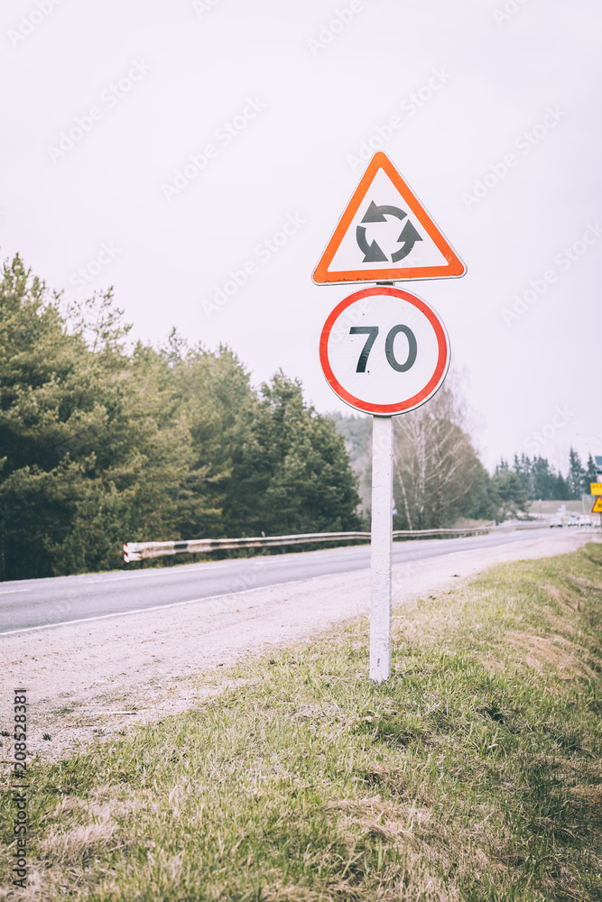 Road sign speed limit to 70 and warning sign that soon there will be a ...