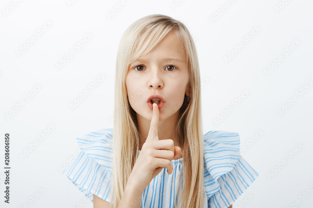 Serious obedient child asks keep voice down, looking after little ...