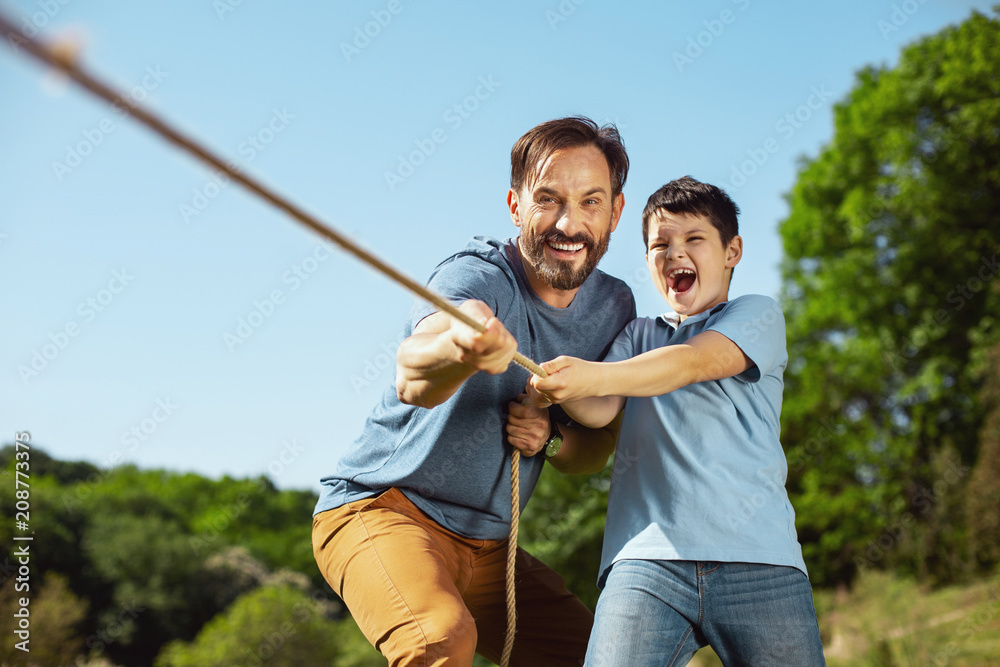 Best team. Inspired loving father helping his son while he pulling a ...
