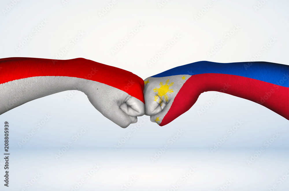 Fist bump of Filipino and Indonesian flags. Two hands with painted ...