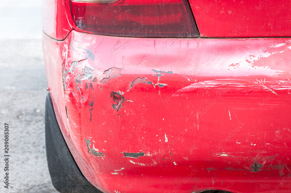 Red damaged car in crash accident with scratched paint and dented rear ...