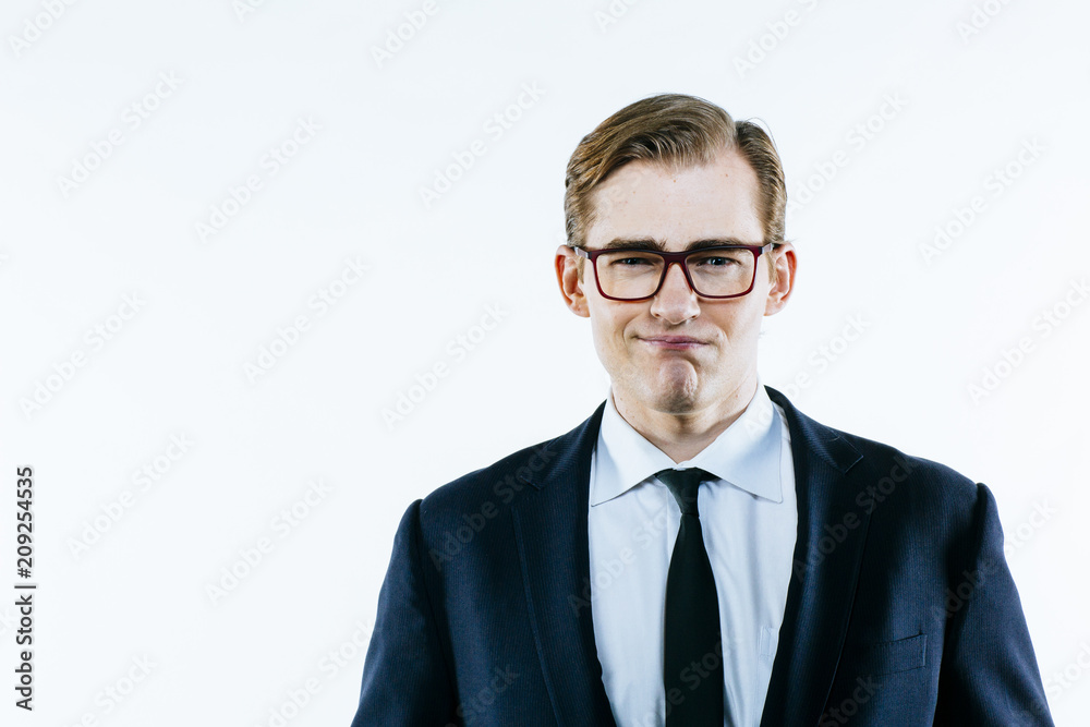 Portrait of a young unconvinced man in suit and tie on white studio ...