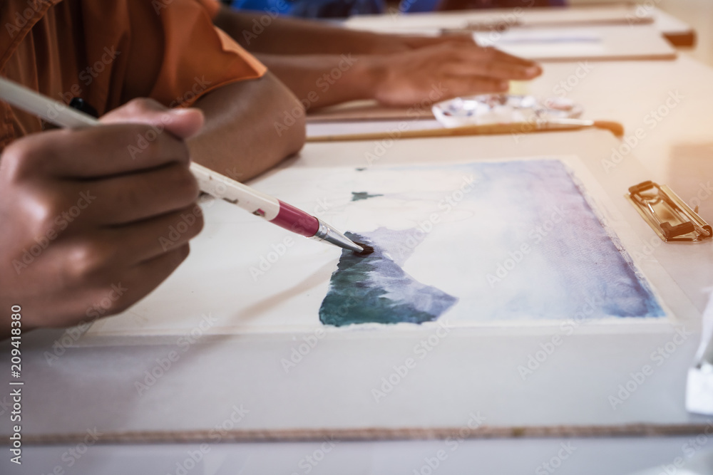 Student's hand with brush drawing on paper for creation picture ...
