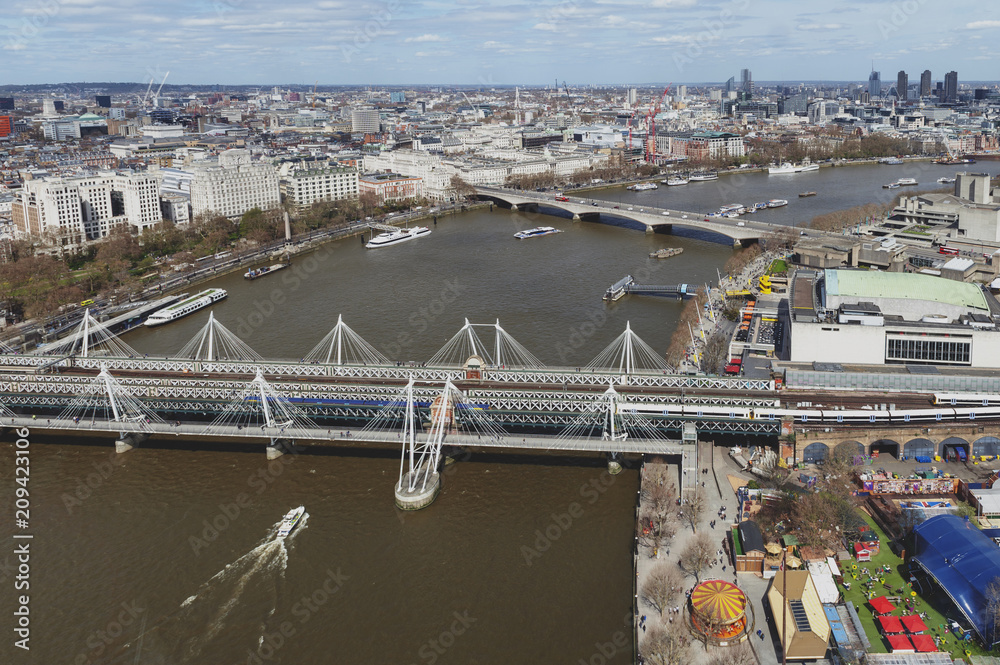 Aerial view of Hungerford Bridge, a steel truss railway bridge, flanked ...